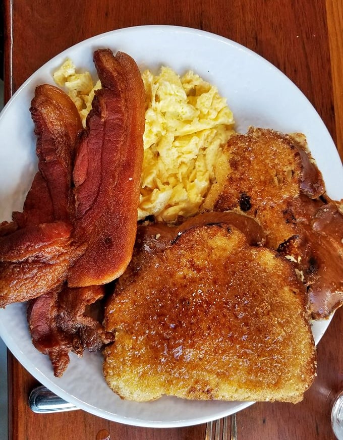 The legendary Crème Brulee French Toast in its natural habitat. That caramelized top shatters like your willpower when the server walks by.