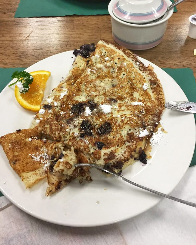 This Danish pancake with blueberries isn't just breakfast—it's edible art with powdered sugar snow and a side of morning sunshine.