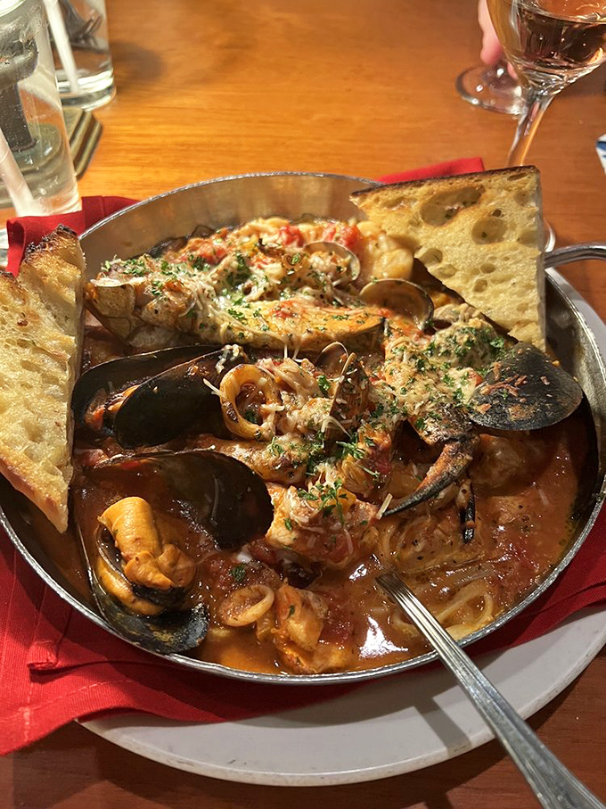 The cioppino – a seafood United Nations where every delegate is swimming in tomato-wine broth diplomacy. Bring extra bread for crucial negotiations.