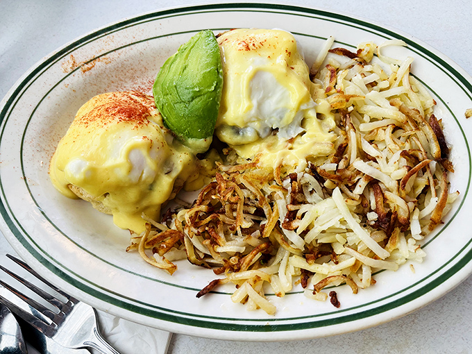 Eggs Benedict with avocado: where breakfast meets California. Those hash browns are doing exactly what hash browns are supposed to do—stealing the show.