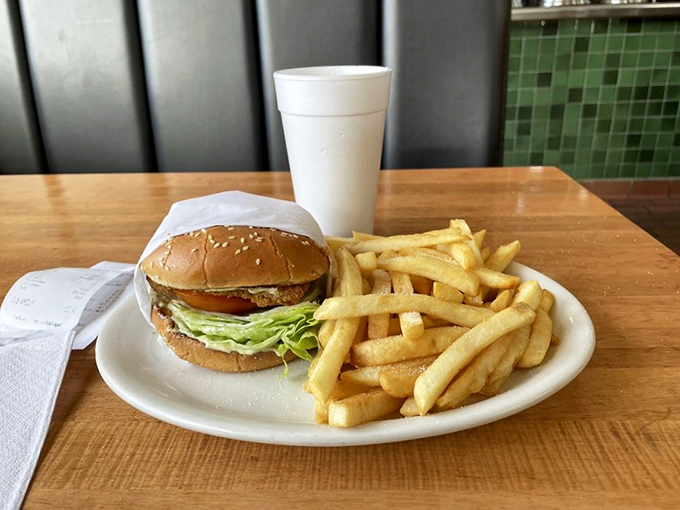 This isn't just a burger—it's architectural brilliance with layers of fresh vegetables, perfectly melted cheese, and a bun that knows its supporting role.