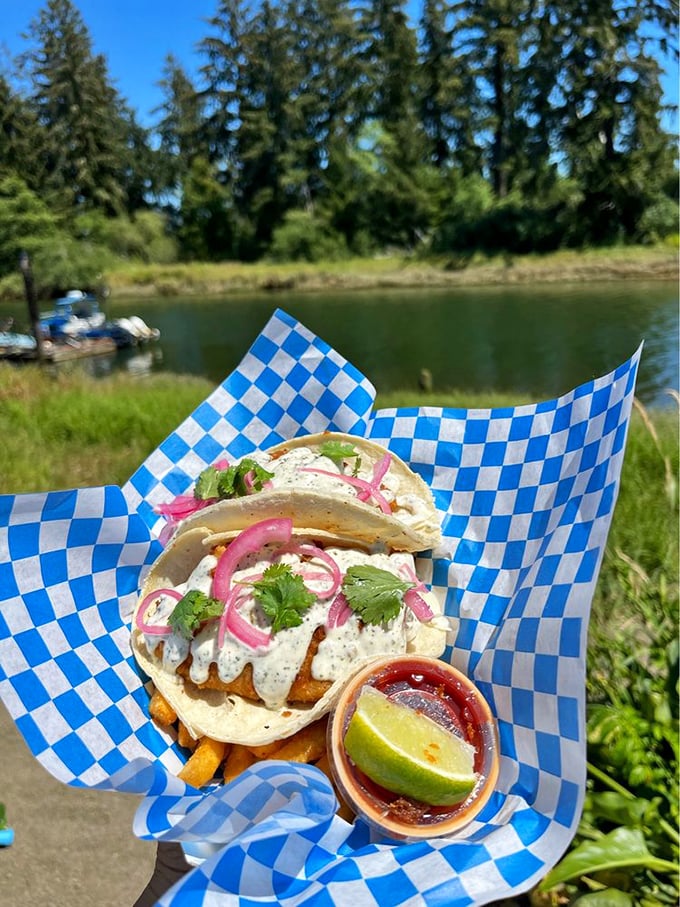 Fish tacos with a view that could make a postcard jealous—pink onions and creamy sauce adding pops of color that match the scenery's splendor.