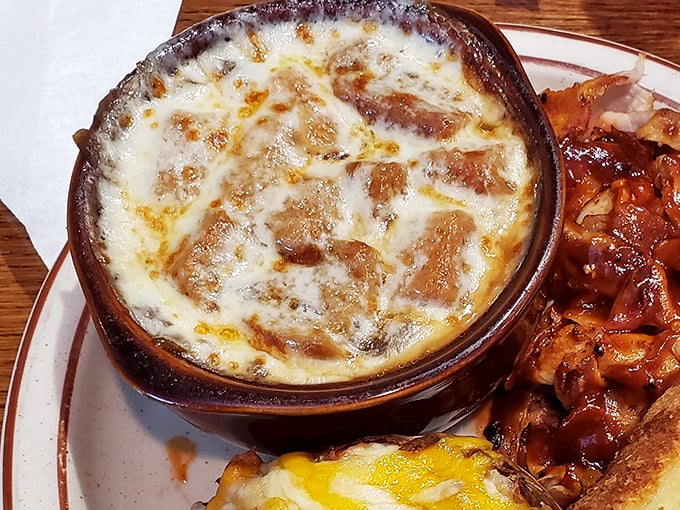 Beneath that golden-brown cheese canopy lies a rich, savory broth – French onion soup that would make Parisian chefs nod in approval.