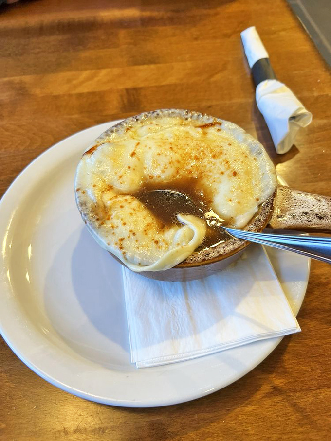 This French onion soup isn't playing games – the melted cheese stretches dramatically with each spoonful, while the rich broth delivers pure satisfaction.v