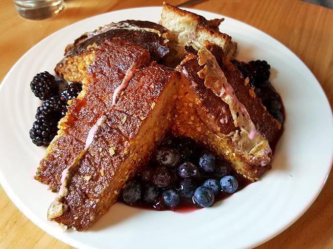 French toast that deserves its own Instagram account—caramelized to perfection and adorned with fresh berries like jewels on culinary royalty.