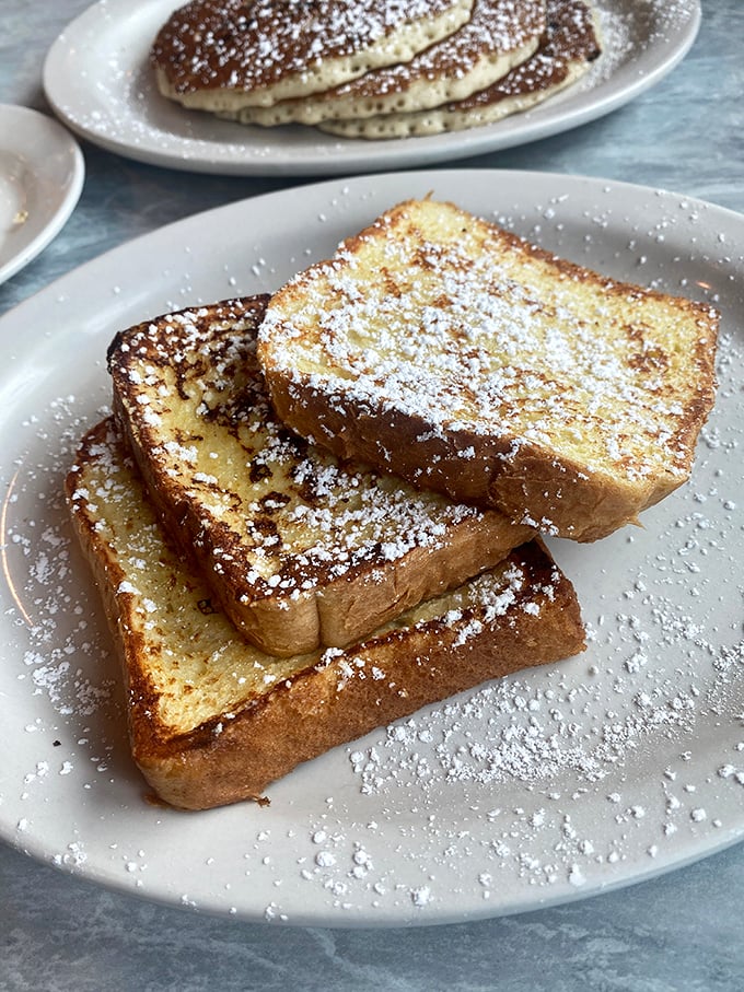 Golden-edged French toast dusted with powdered sugar—the kind that makes you wonder why anyone would ever skip breakfast.
