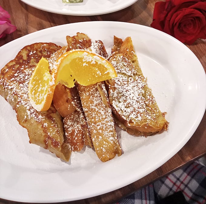 French toast that's dressed for success with powdered sugar snowfall and citrus accessories—breakfast's answer to formal wear.