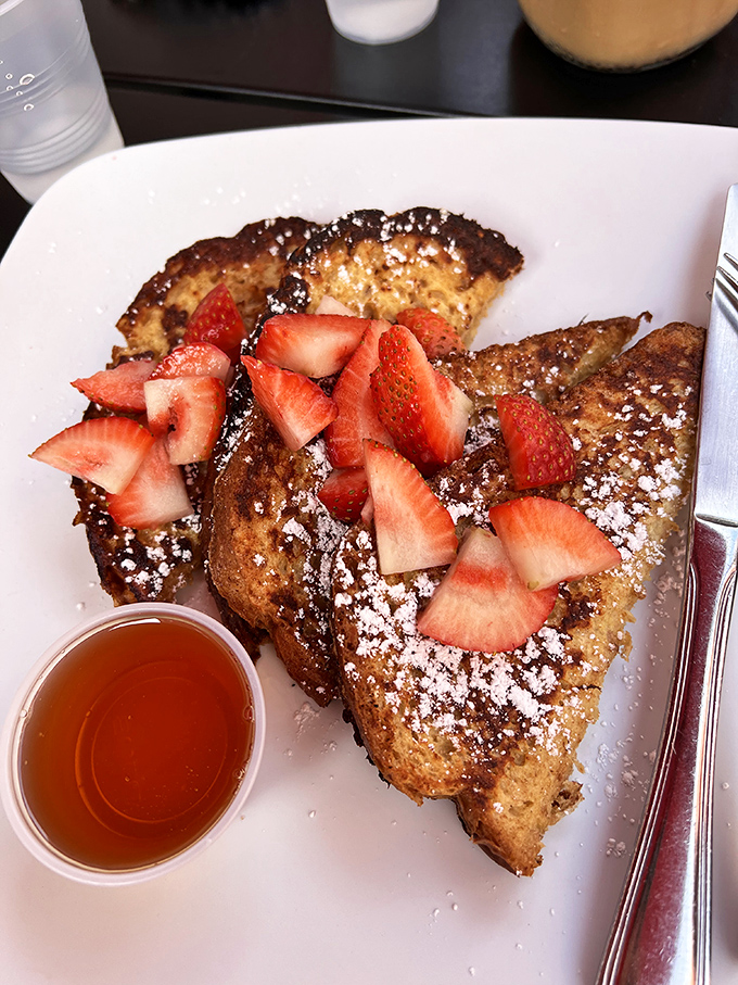 French toast that strikes the perfect balance—crispy edges, custardy center, and fresh strawberries that pop with every bite.