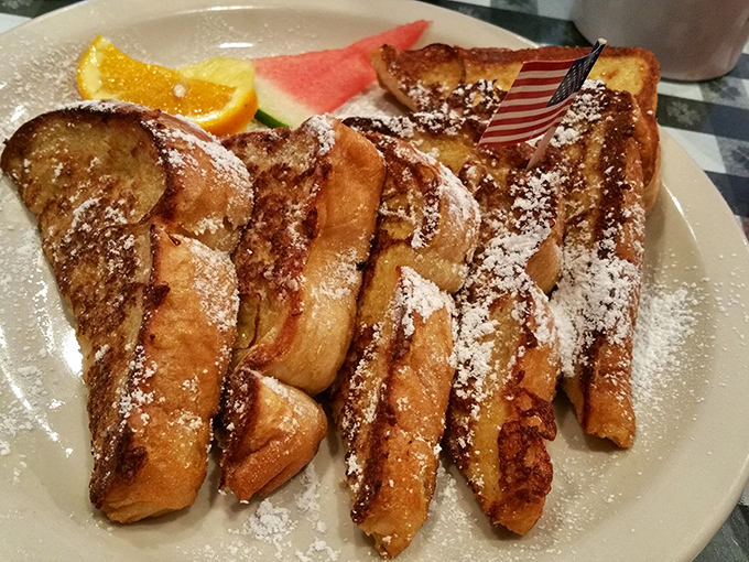 French toast that's dressed for success—powdered sugar dusted like fresh snow, with fruit sidekicks waiting in the wings.