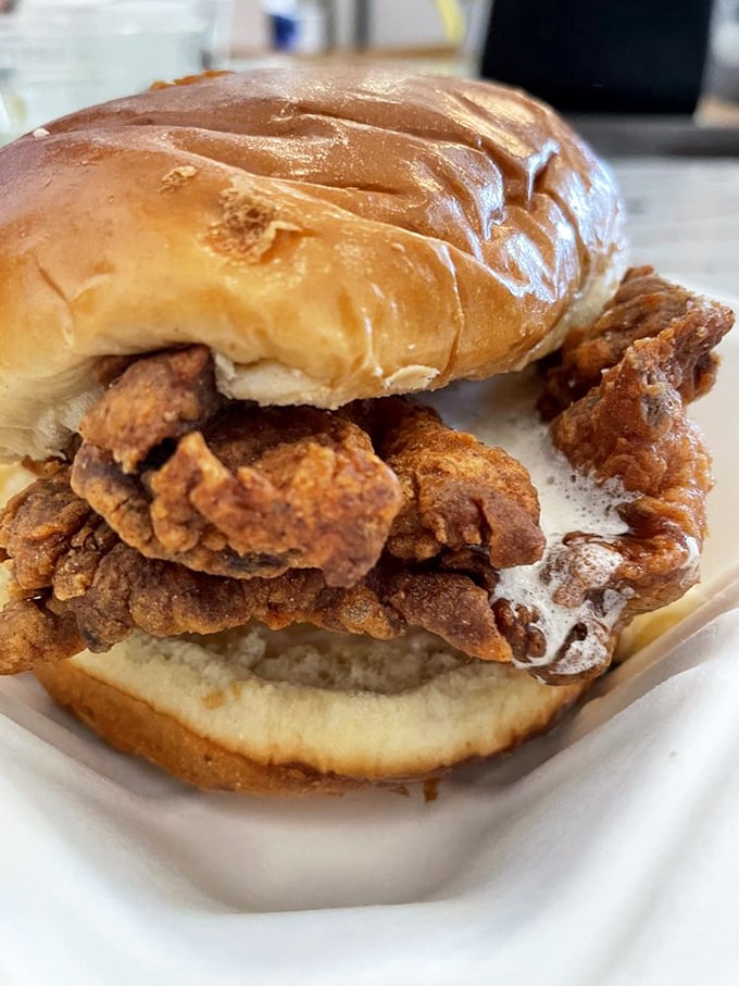 The sandwich that launched a thousand return visits—crispy fried chicken spilling out of a soft bun in a way that makes napkins absolutely necessary.