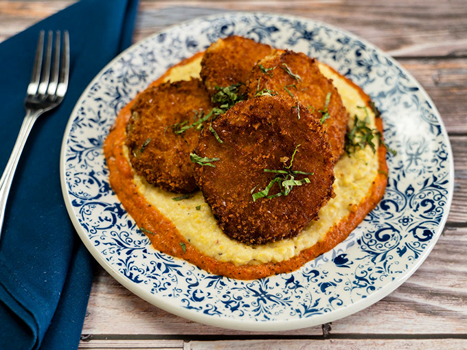 Fried green tomatoes resting on creamy grits—proof that sometimes the best things in life are those that refuse to ripen too quickly.