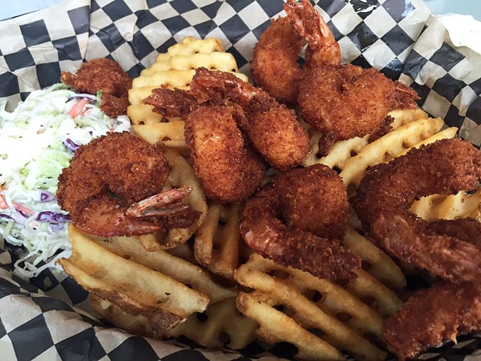 Golden-fried shrimp nestled on waffle fries—proof that sometimes the most beautiful things in life come in checkered paper baskets.