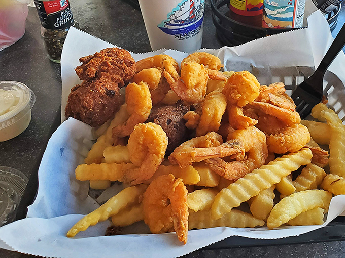 A mountain of golden fried shrimp atop crispy fries—proof that sometimes the simplest pleasures are the most profound. The seafood equivalent of a standing ovation.