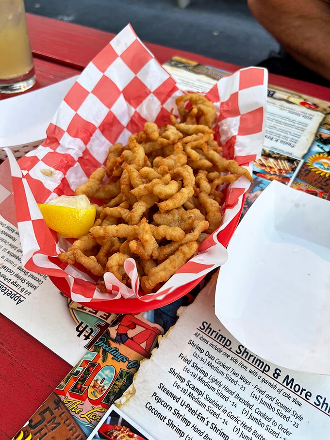 Golden-fried clams nestled in a red-and-white checkered basket—seafood's version of casual Friday. That squeeze of lemon isn't optional, it's an essential flavor key.