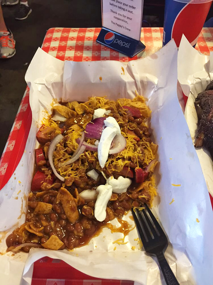 A beautiful mess of flavors—pulled meat, cheese, onions, and what appears to be Fritos, creating the kind of dish you'd happily eat in secret.