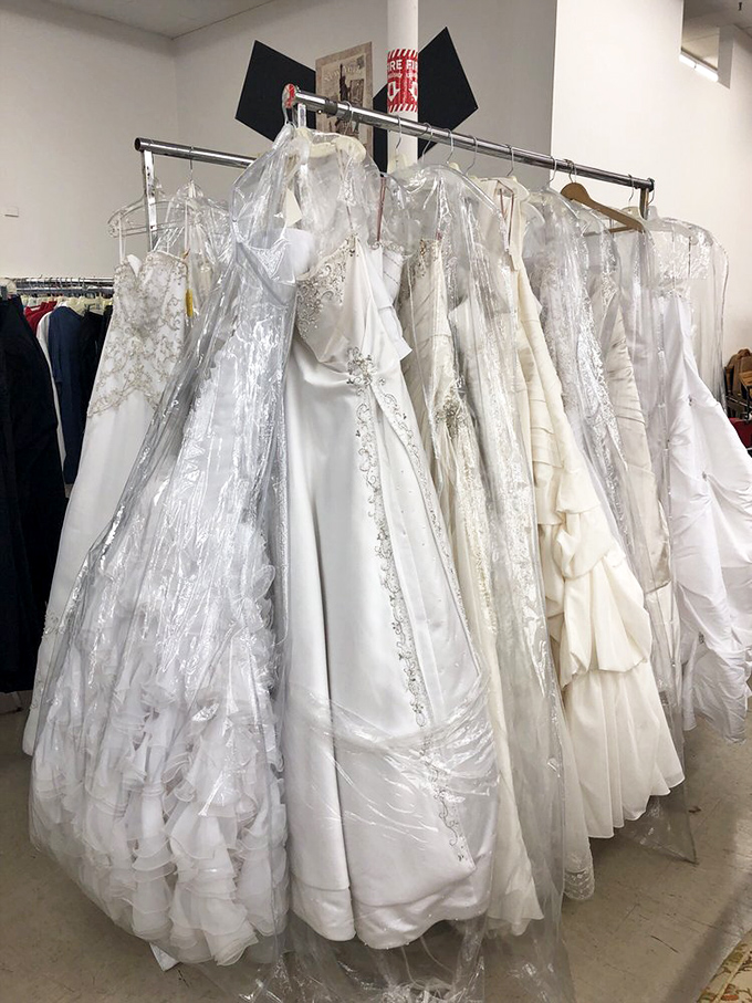 Wedding gowns hang like ghosts of celebrations past, each waiting for a second chance to witness "I do."