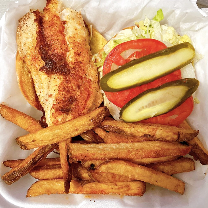 A sandwich that captures the essence of Florida – grilled grouper, fresh veggies, and those gloriously crispy fries that demand to be savored.