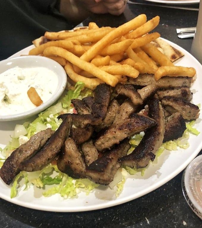 Seasoned gyro meat resting on a bed of crisp lettuce, accompanied by golden fries and tzatziki—proof that Sterling, Virginia knows its Mediterranean flavors.