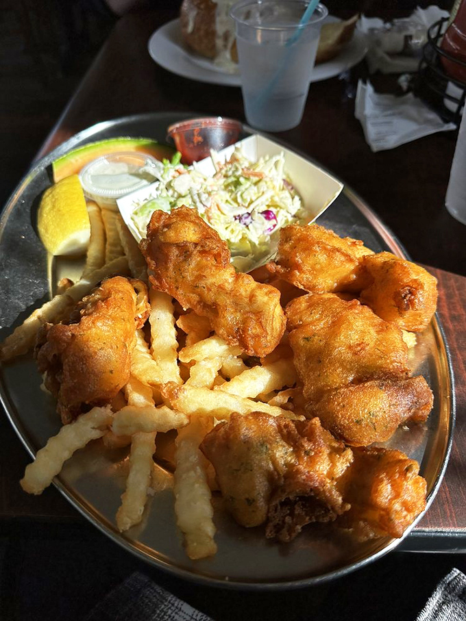 Fish and chips that would make a British pub owner weep with jealousy – golden, crispy batter protecting flaky white fish, with fries that demand to be fought over.