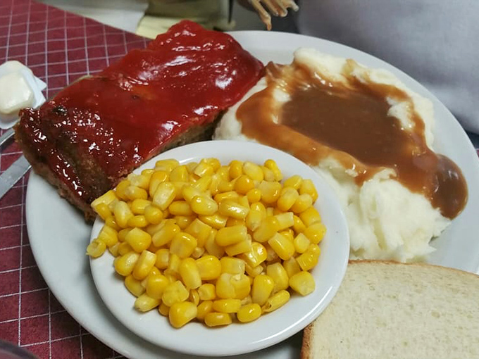 Comfort food doesn't get more nostalgic than this—meatloaf glazed to perfection alongside mashed potatoes drowning happily in gravy.