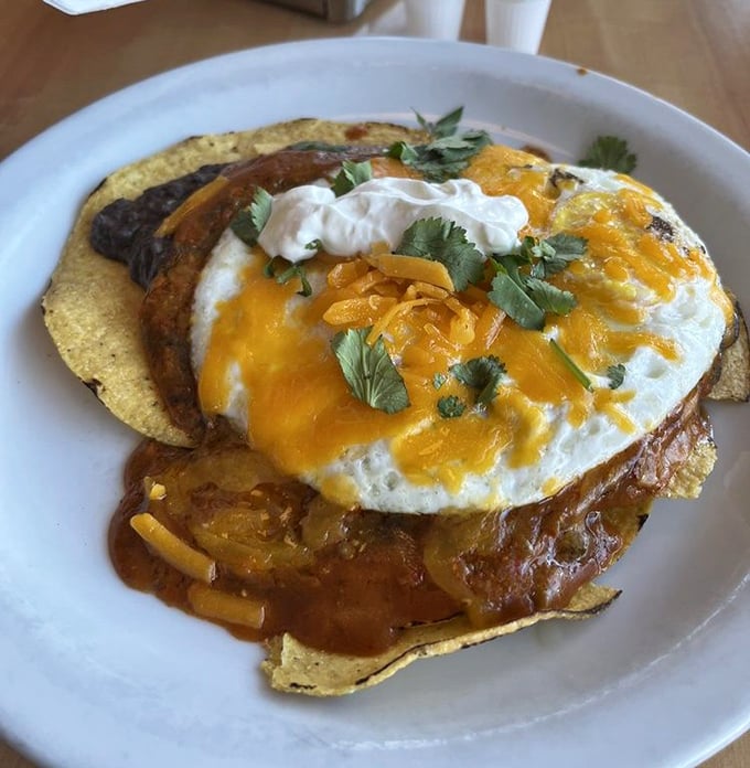Breakfast architecture at its finest—crispy tortillas, perfectly runny eggs, and a sauce that could wake you up faster than three espressos.
