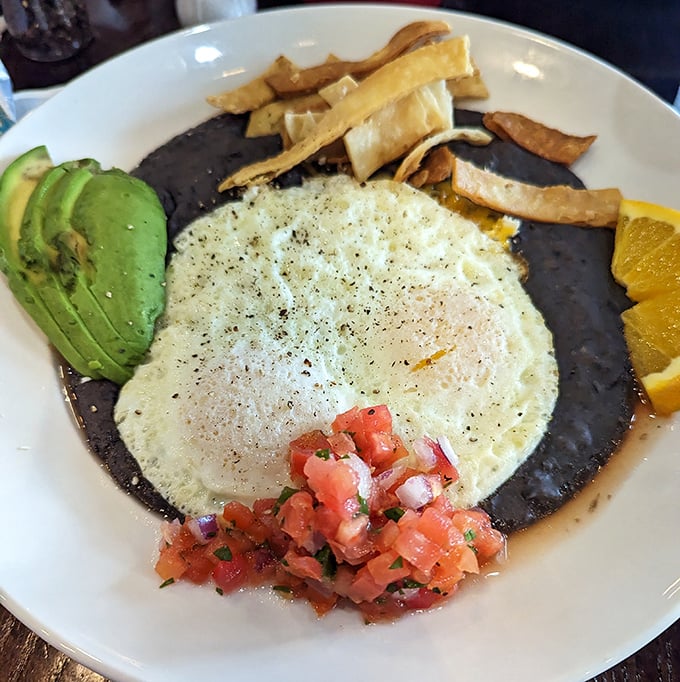 Black beans, fresh eggs, and vibrant pico de gallo—a breakfast fiesta that doesn't require a passport or questionable street food decisions.