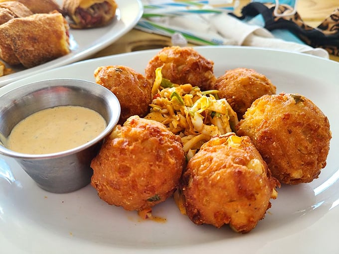 These hush puppies aren't just side dishes—they're golden orbs of cornmeal perfection that deserve their own spotlight and accompanying sauce.