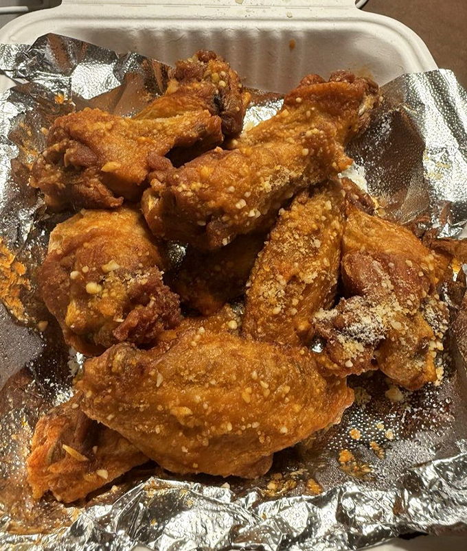 These wings aren't just crispy—they're wearing a garlic parmesan coating that could make angels sing and cardiologists frown simultaneously.