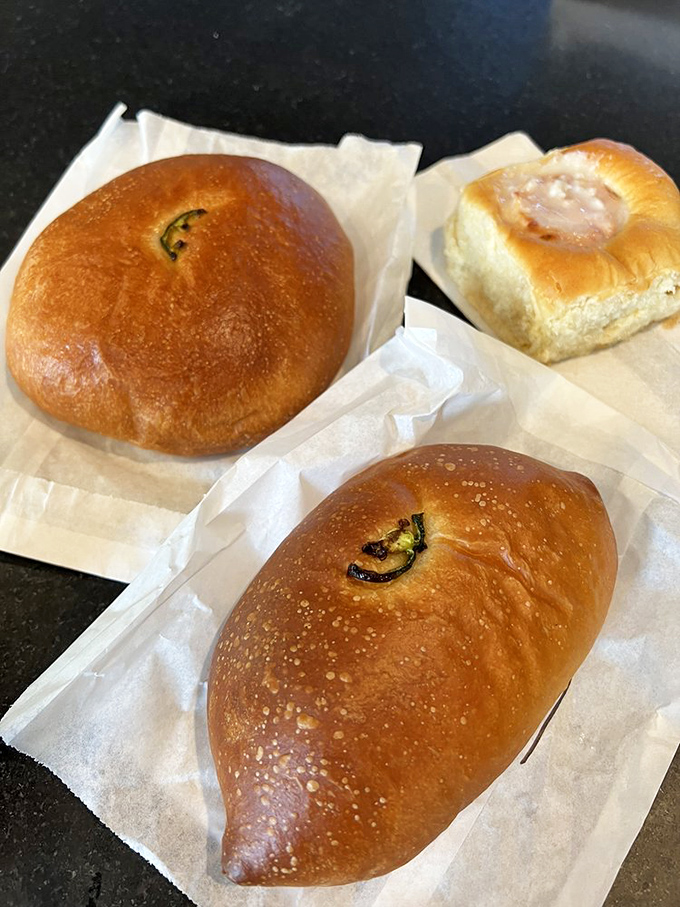 The holy trinity of kolache perfection: pillowy dough, savory fillings, and that telltale hint of jalapeño peeking through like a green gem.