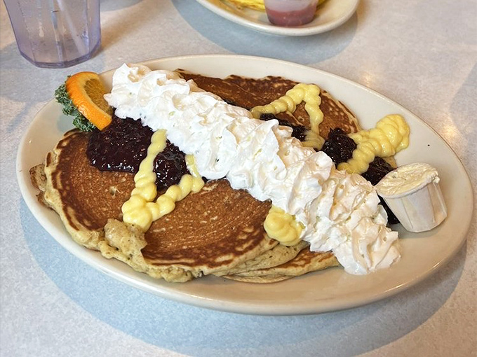 Pancakes that don't just sit on the plate—they perform. With whipped cream, fruit compote, and what appears to be artistic drizzles, this is breakfast as theater.
