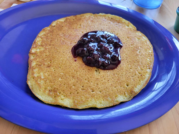 Pancake perfection isn't complicated—just a golden disc, a dollop of blueberry compote, and the willpower not to order seconds (which you'll lack).