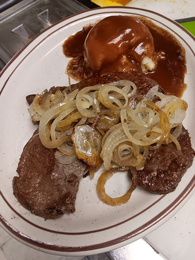 Liver and onions with a side of mashed potatoes—a dish that separates casual diners from true comfort food connoisseurs.