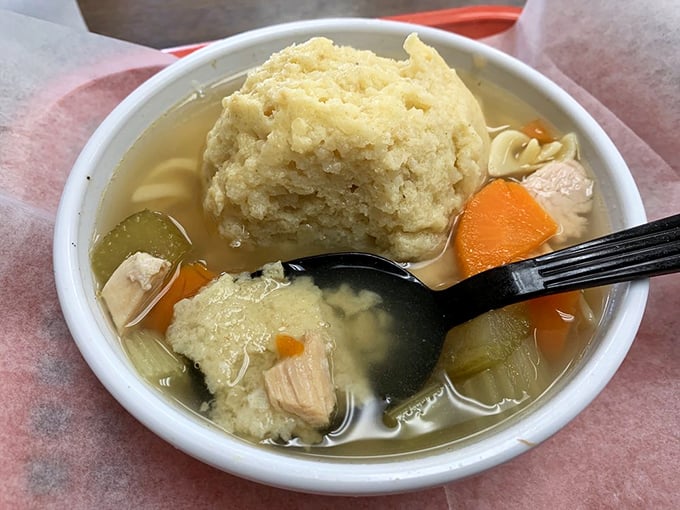 The matzo ball soup—where a dumpling the size of a baseball floats majestically in golden broth like the moon orbiting a delicious planet.