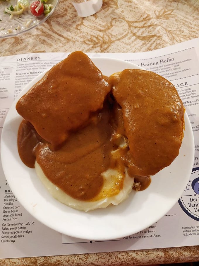 Meatloaf swimming in gravy that would make your grandmother both jealous and proud. This isn't food; it's an edible hug on a white plate.