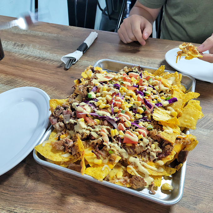 Loaded nachos that require a strategy to eat—each chip a vehicle for maximum topping delivery. The kind of sharing plate nobody wants to share.