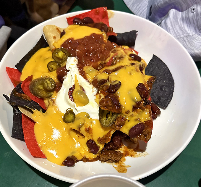 These Nachos Grande aren't messing around—a mountain of tortilla chips buried under an avalanche of cheese, chili, and jalapeños that demands to be shared.