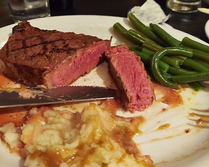 The New York Strip, sliced to reveal that perfect pink center—proof that simplicity, when executed flawlessly, needs no embellishment.