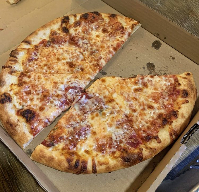 The New York-style cheese pizza in its natural habitat—a cardboard box. Simple, foldable, and proof that sometimes the classics need no improvement.