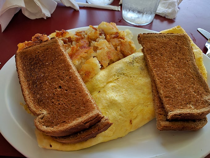 The breakfast trinity: perfectly folded omelet, golden-brown toast, and home fries that somehow manage to be both crispy and tender—a morning miracle.