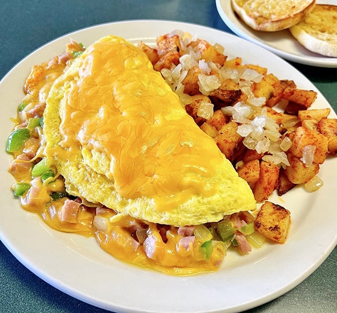 Cheese doesn't just top this omelet—it creates a golden canopy. Paired with seasoned potatoes, it's breakfast engineering at its finest.