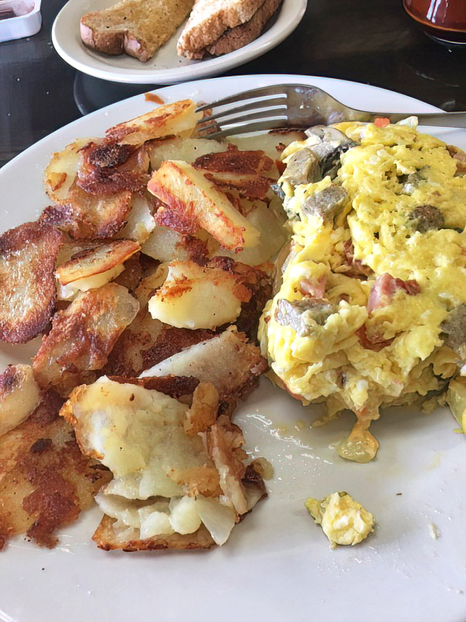 Behold the omelet that locals drive across town for – fluffy, generous, and absolutely magnificent.