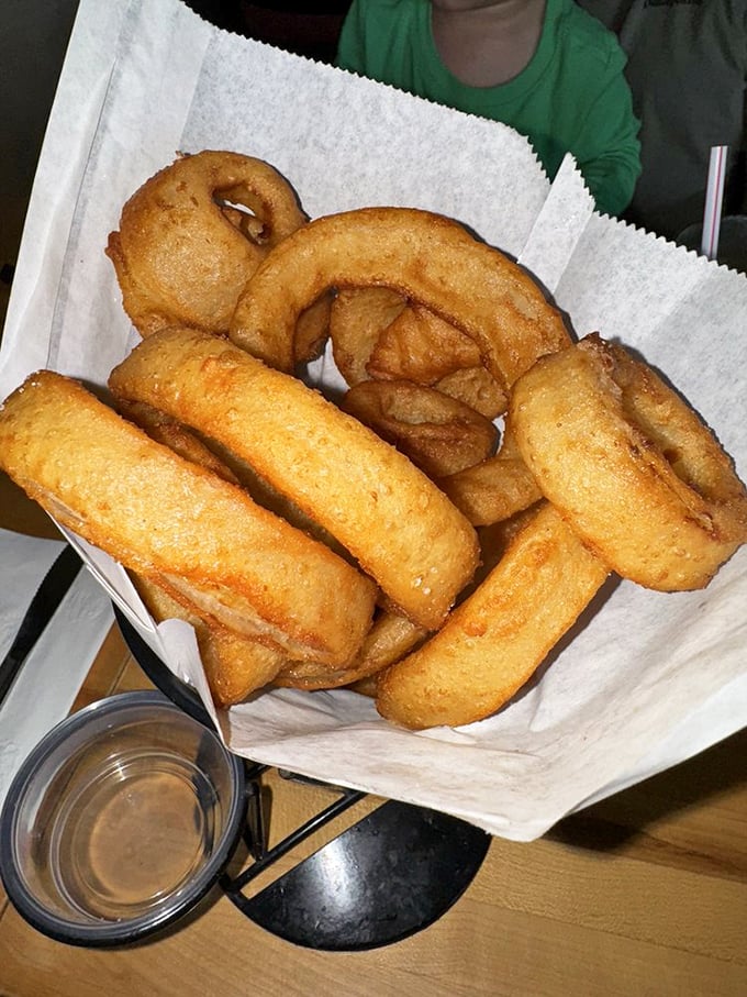 Golden onion rings that crunch like autumn leaves – except instead of yard work, you get dipping sauces and happiness.