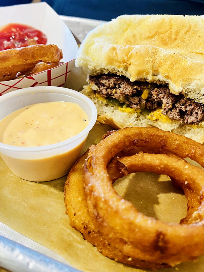 That perfect onion ring—crispy exterior giving way to sweet onion inside—paired with a burger that's worth crossing county lines for.