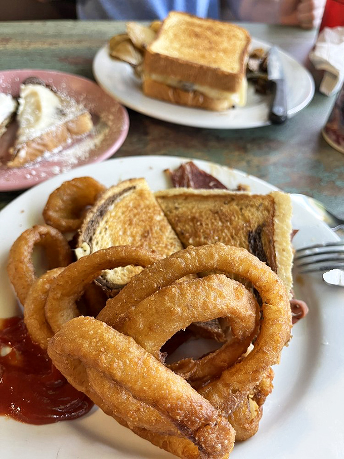 Golden onion rings that crunch loud enough to turn heads – paired with that perfectly toasted sandwich, it's lunch nirvana on a well-worn plate.