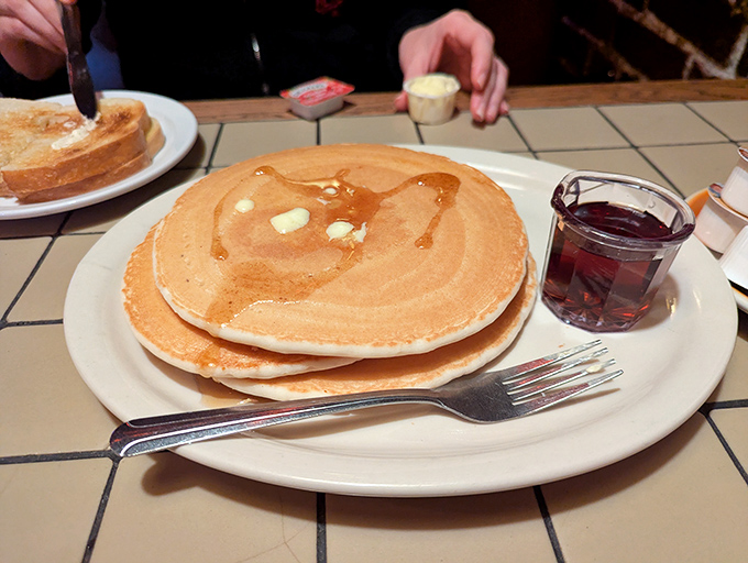 Pancakes so large they require their own zip code, golden-brown and ready to soak up maple syrup like a delicious sponge.