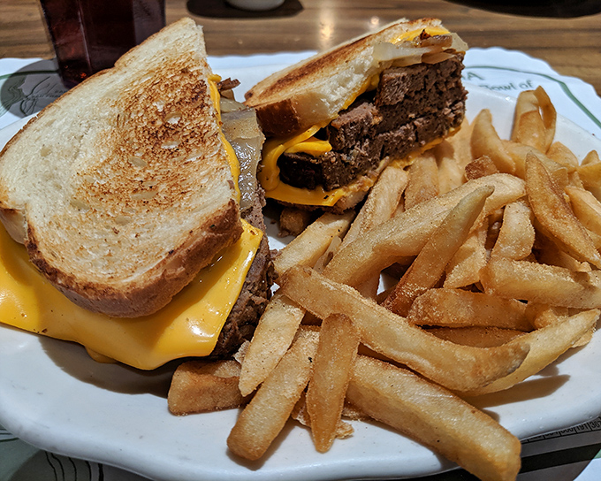The patty melt—that glorious marriage of beef, melted cheese, and grilled bread—served with fries so perfectly golden they deserve their own Instagram account.
