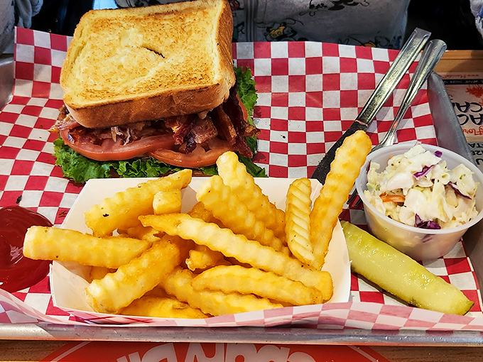 This sandwich isn't just lunch—it's architecture. Layers of savory goodness nestled between perfectly toasted bread with crispy fries standing guard alongside.