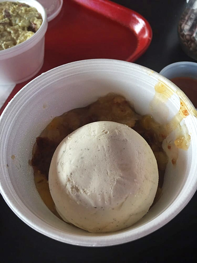 Peach cobbler topped with ice cream: proof that sometimes the simplest pleasures are the most profound. The warm-cold contrast is pure genius.