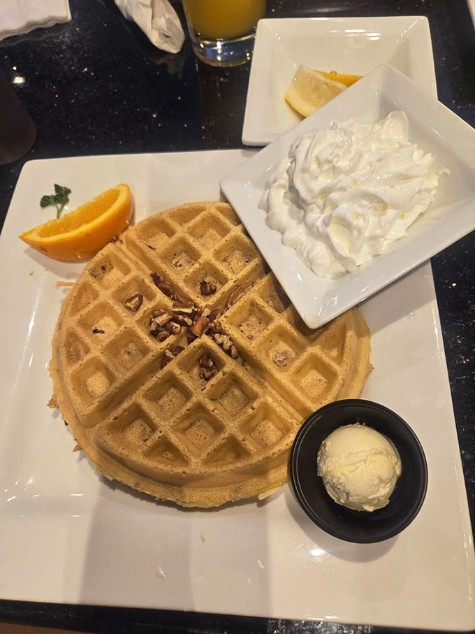 This pecan waffle arrives with whipped cream mountains that would make ski resorts jealous of the peaks.