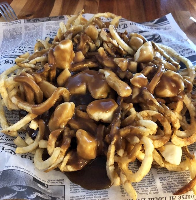 Poutine that would make Canadians apply for dual citizenship—crispy fries swimming in gravy with cheese curds playing the most delicious game of hide-and-seek.